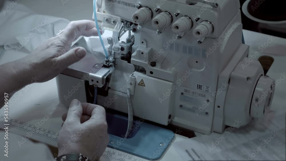 Seamstress's hands are stitching fabric on a professional industrial ...