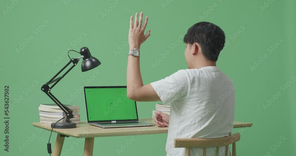 Young Male Raising His Hand And Speaking While Typing On Green Screen ...