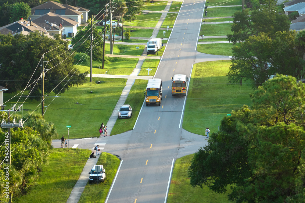 Top view of standard american yellow school bus picking up kids at ...