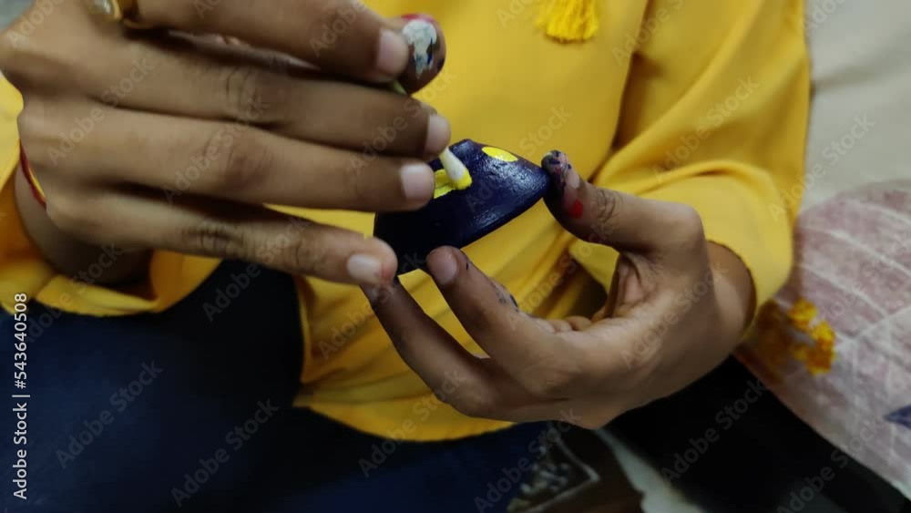 Footage of Indian girl making Diya with clay and decorating them ...