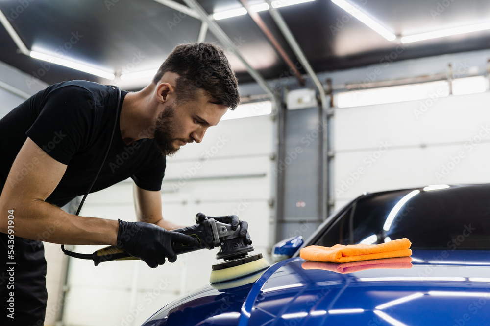 Car polishing with orbital polisher for remove scratches. Worker of ...