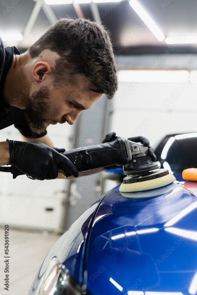 Car polishing with orbital polisher for remove scratches. Worker of ...