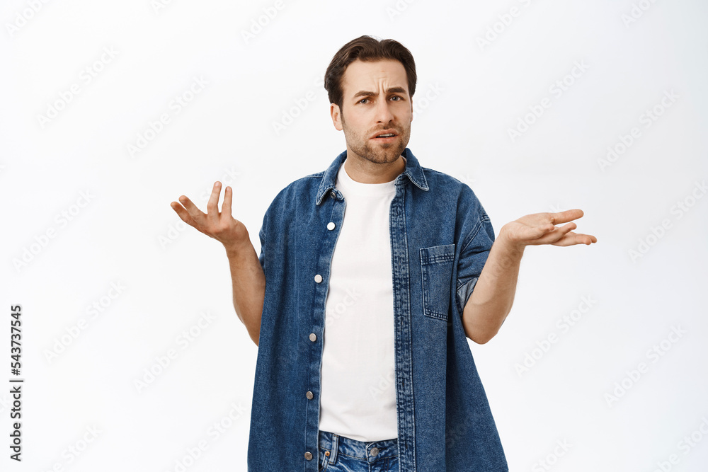 Portrait of man shrugs and looks confused, dont understand smth, stands ...