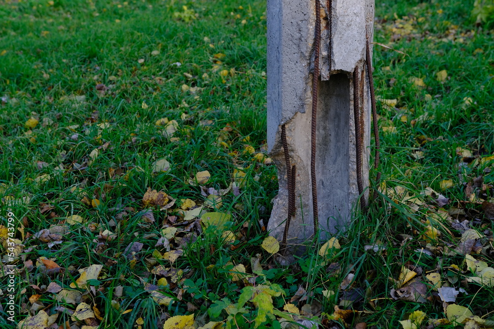 A close-up view of a dilapidated concrete column battered by an ...