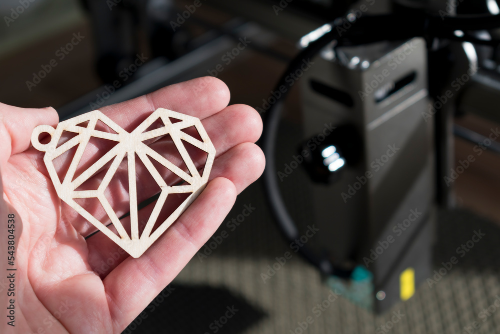 Laser engraving and cutting, hand holding an example of a cut out ...