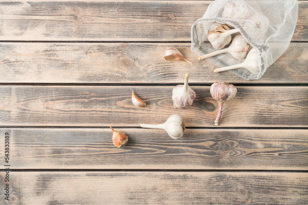 Bunch of unpeeled garlic on faded wooden table, top view. Eco fabric ...
