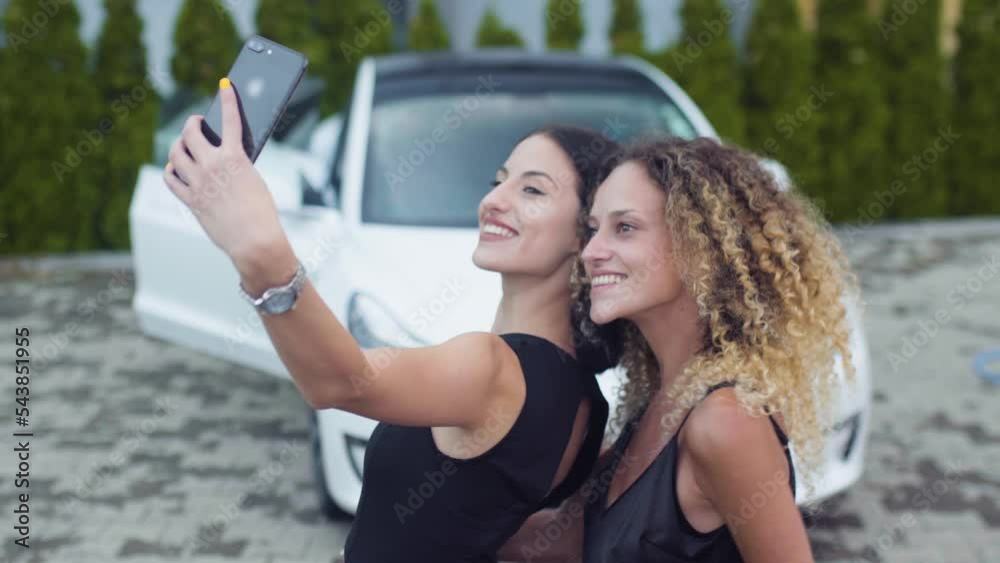 Two beautiiful girls in black outfut smiling and posing for a selfy ...