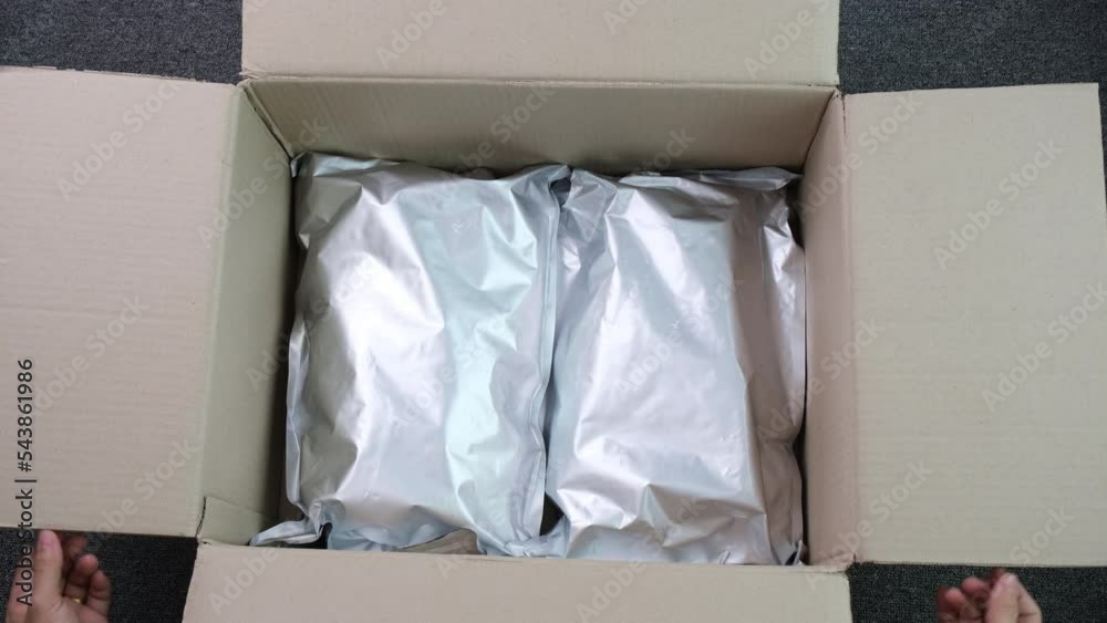 Close-up of hands opening a cardboard box with a product. The female ...