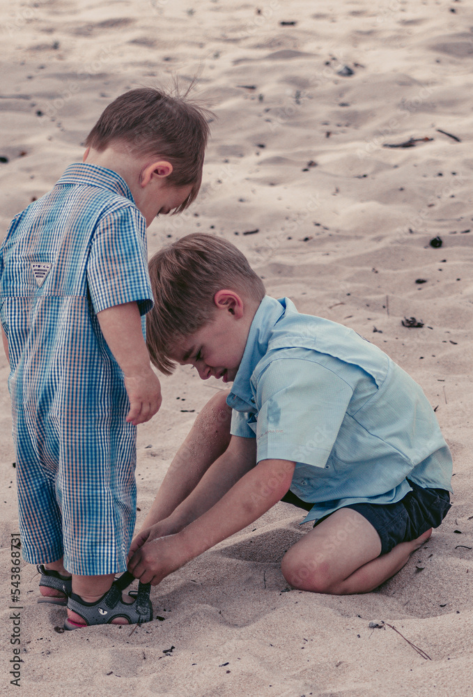 Foto de two adorable boy children, brother helping his younger brother ...