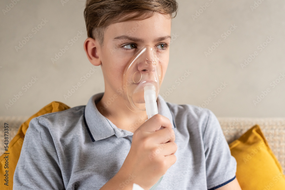Foto de Sick teen boy with an inhaler. Unhealthy child doing inhalation ...