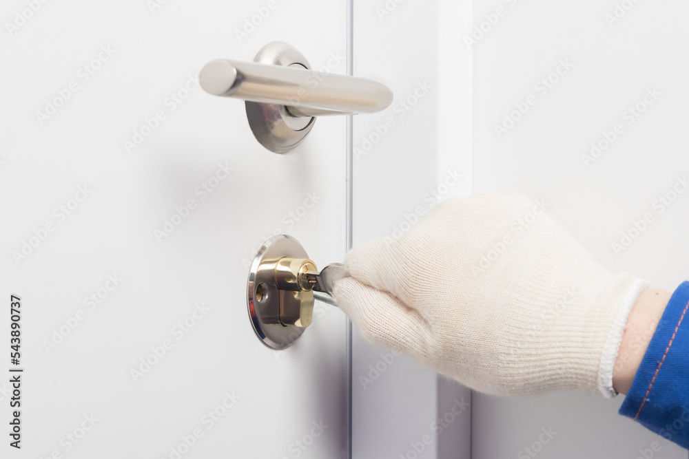 gloved hand opens door lock with key Stock Photo | Adobe Stock