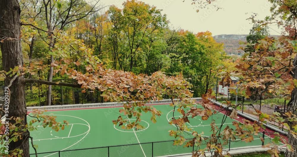 Aerial video of a new green and red outdoor basketball court at school ...