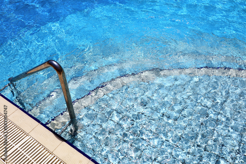 Steps for descending into the swimming pool with a metal handrail ...