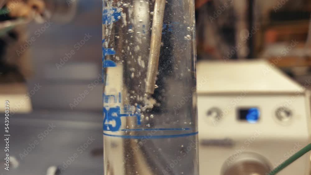 Nitrogen bubble through organic solvent in measuring cylinder in a ...