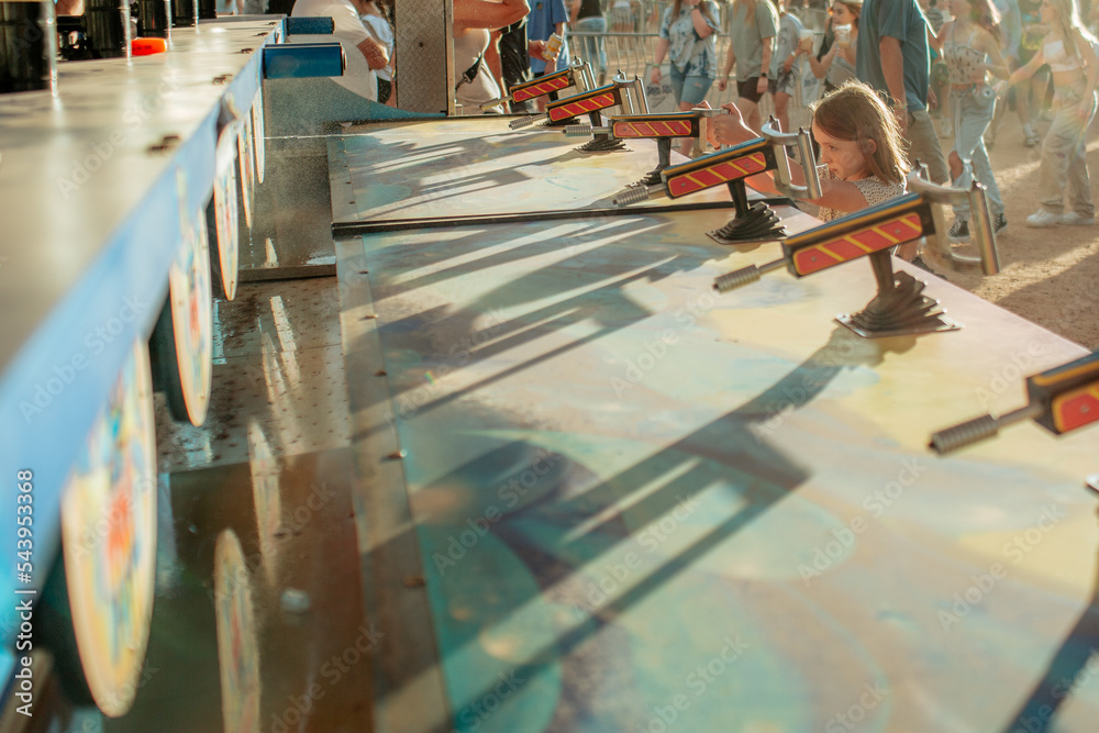 focused young girl playing carnival game Stock Photo | Adobe Stock