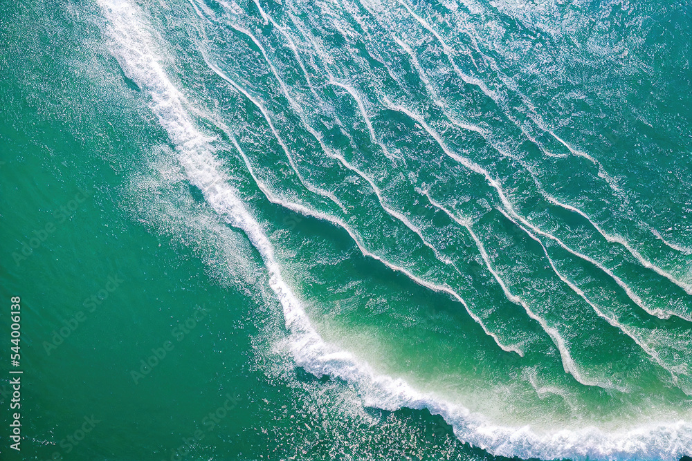 Top view of waves breaking on a beach, water splits the composition in ...