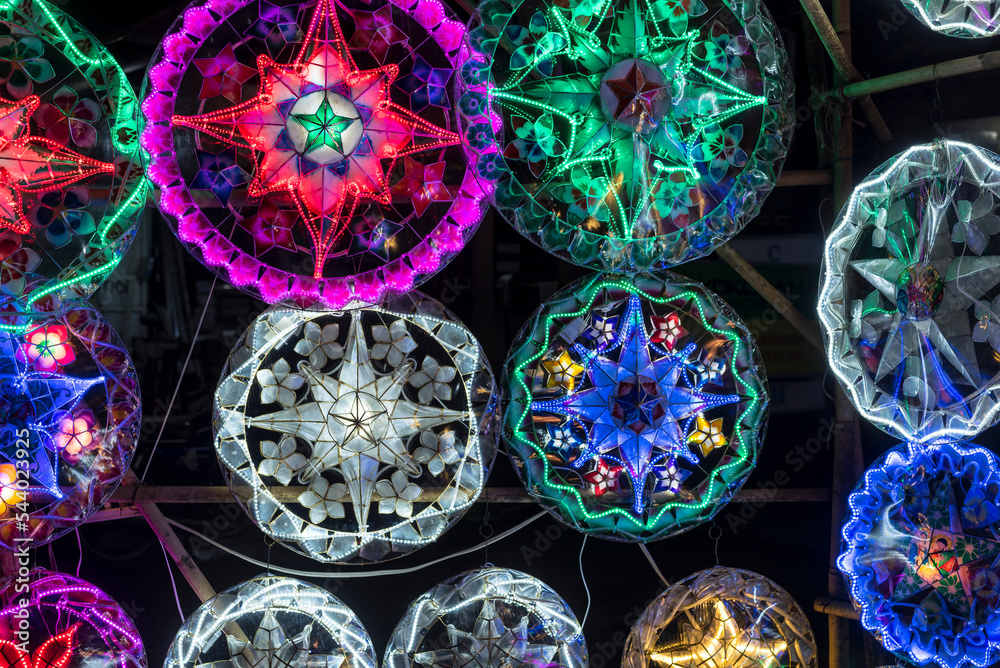 Brightly colored Parols for sale at a stand at nighttime. A Filipino ...