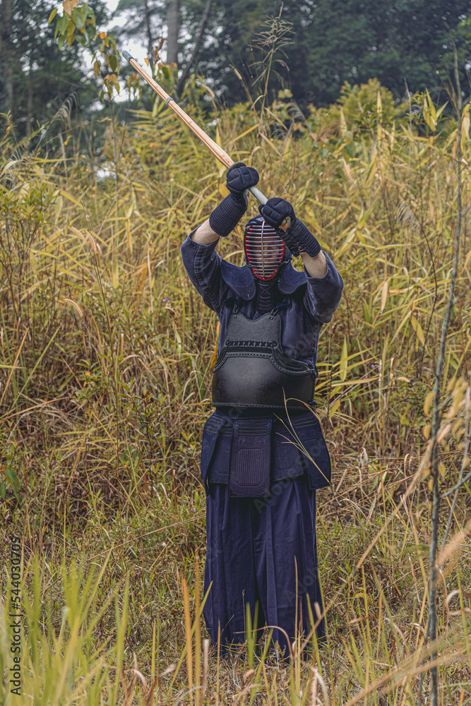 Full-length portrait of kendoka man in the forest holding the sinai ...