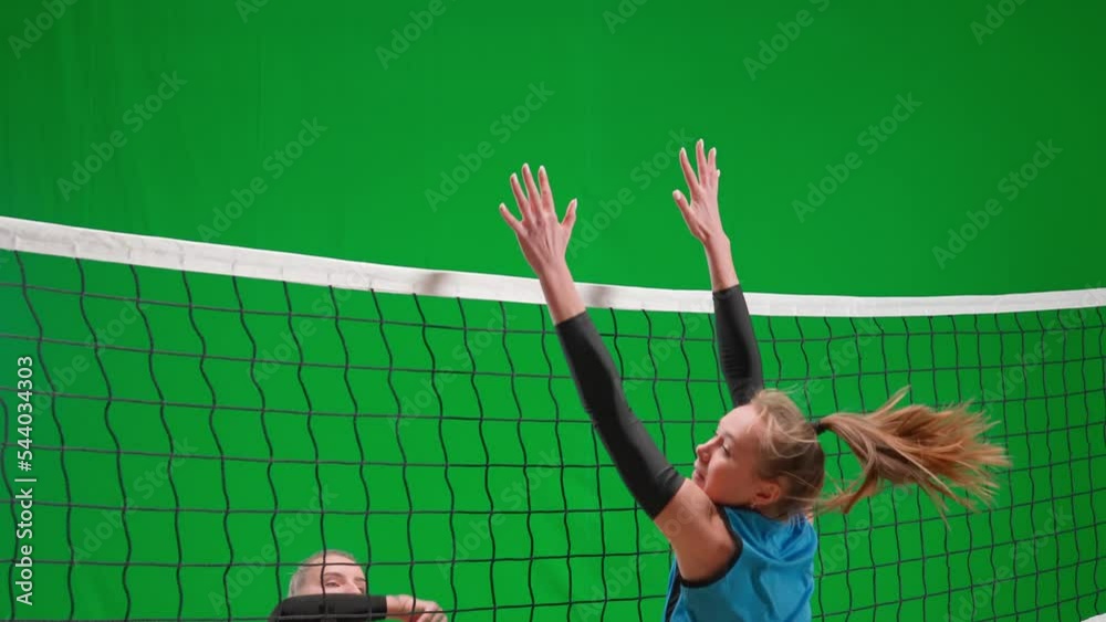 Two young women in sportswear playing volleyball on green screen chroma ...