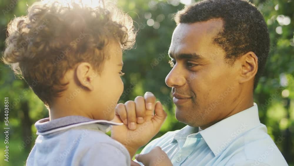 Lovely biracial father and his curly dark-haired son having fun ...