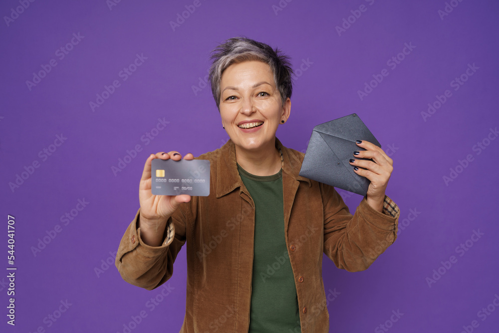Holding credit, debit card mature woman with fancy dark envelope. Happy ...