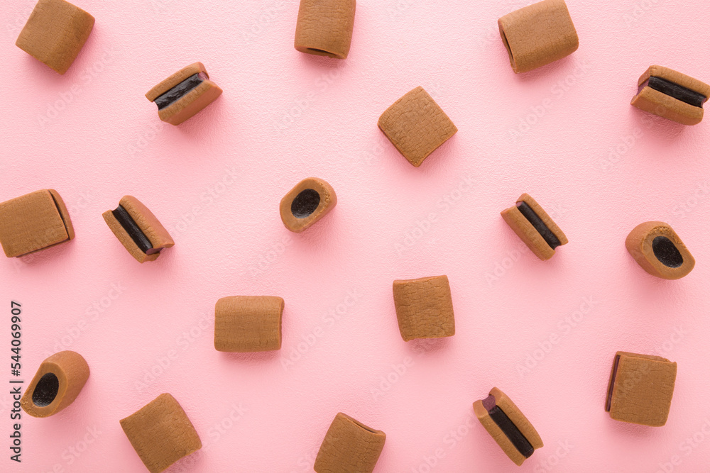 Dark brown chocolate jelly gummy candies on light pink table background ...