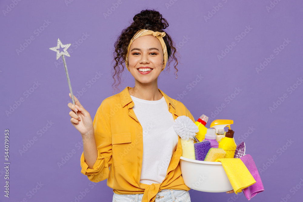 Young happy housekeeper woman wear yellow shirt tidy up hold basin with ...