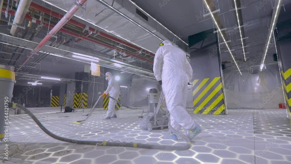 Grinding a concrete floor with a grinder. Builder works concrete floor ...