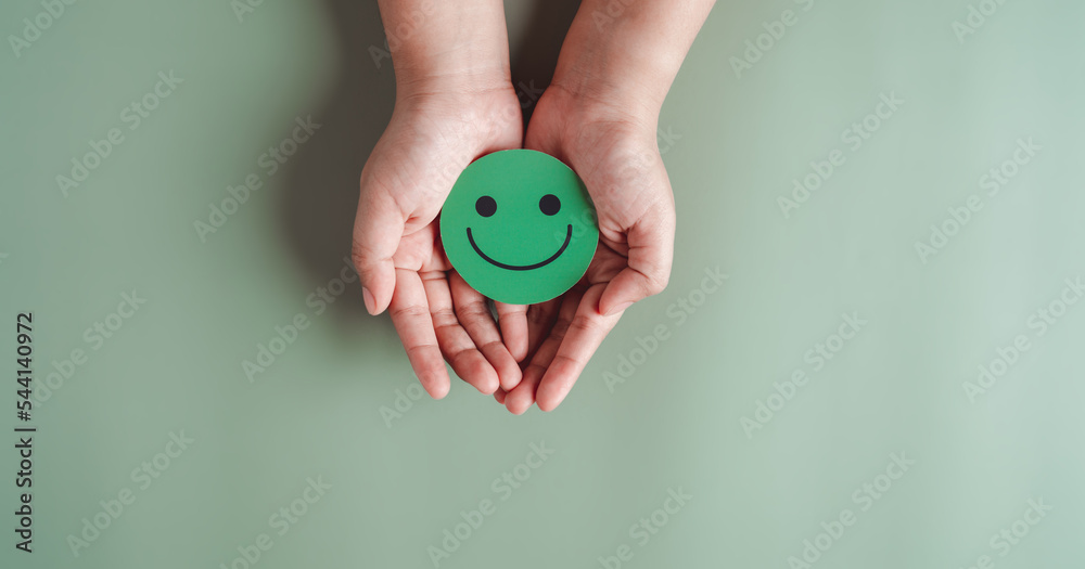 Hands holding green happy smile face, good feedback rating, positive ...