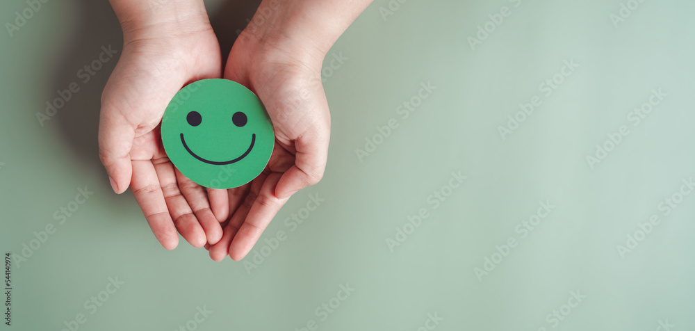Hands holding green happy smile face, good feedback rating, positive ...