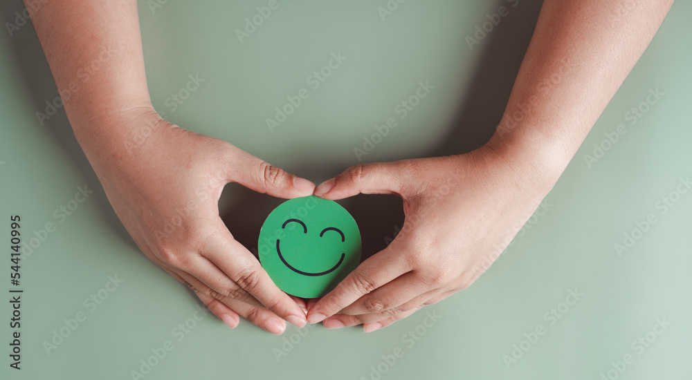 Hands holding green happy smile face, good feedback rating, positive ...