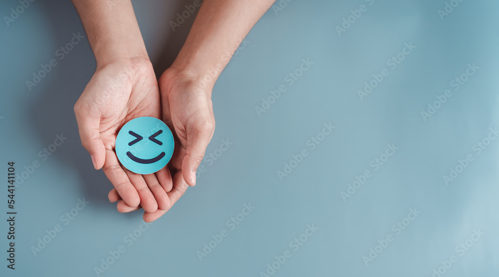 Hands holding blue happy smile face, good feedback rating, positive ...