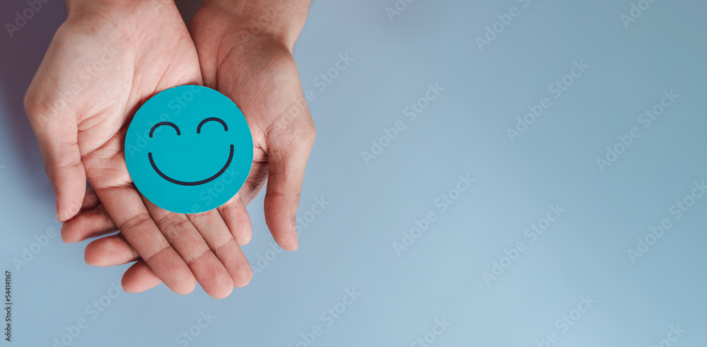Hands holding blue happy smile face, good feedback rating, positive ...
