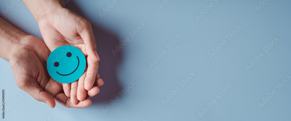 Hands holding blue happy smile face, good feedback rating, positive ...