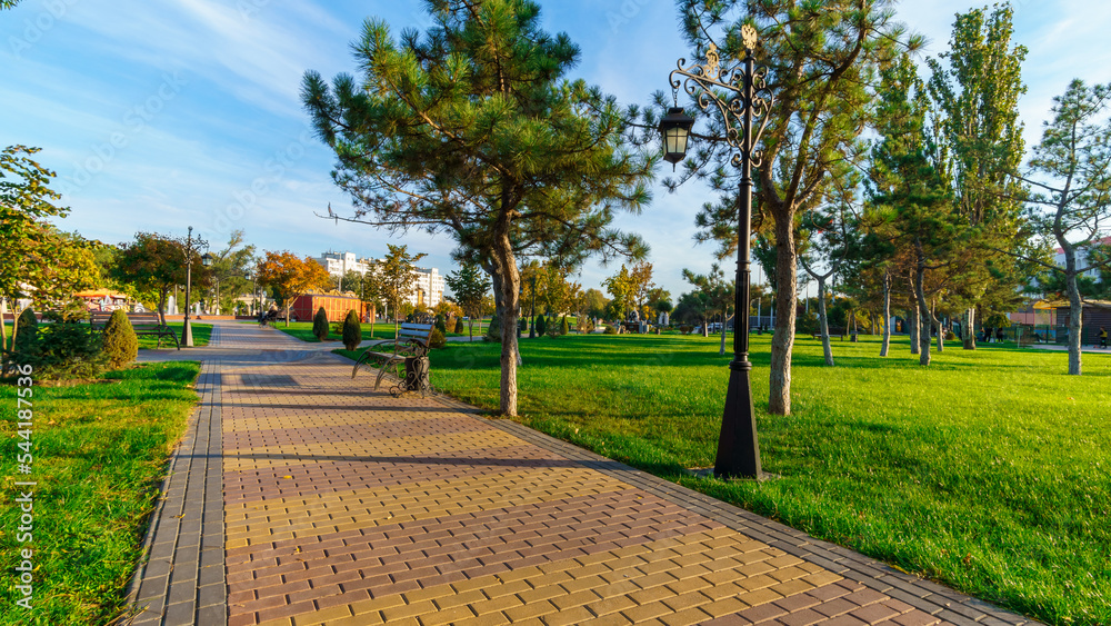 city park, green lawns and trees, random people walking along the paths ...