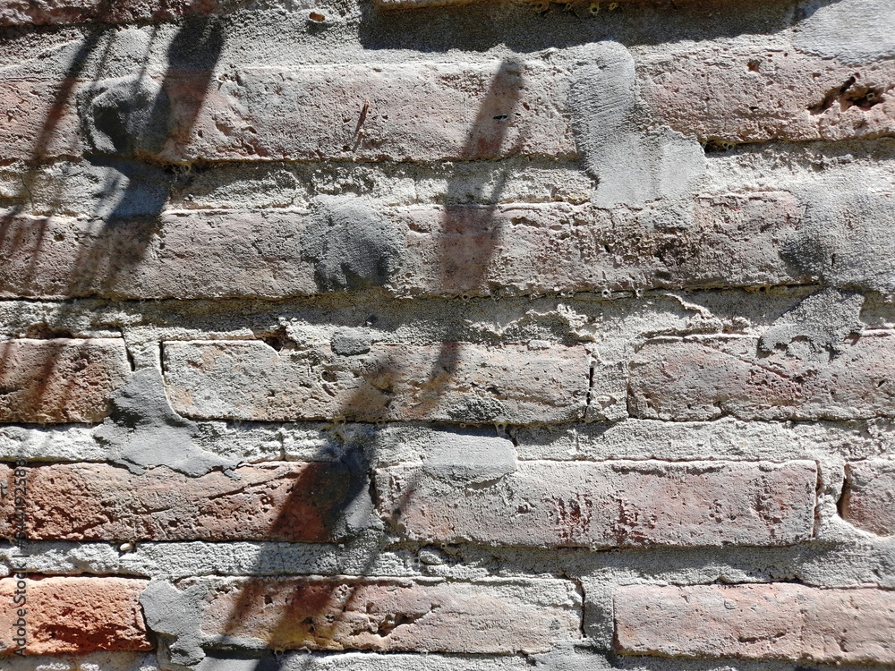 Muro de ladrillos de arcilla con concreto en el jardìn de la casa, con ...