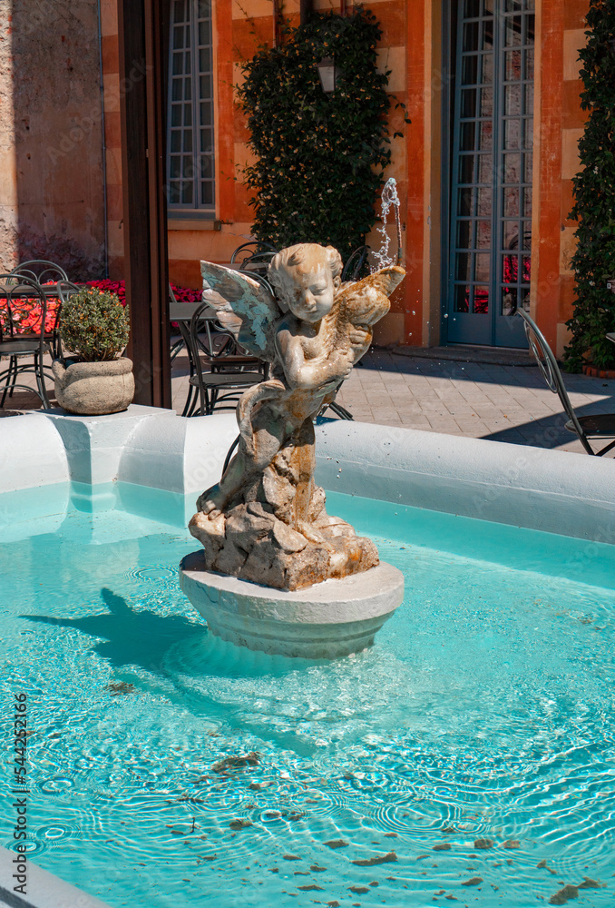Statue of Cupid in the pool of water in the garden of Villa Cipressi ...
