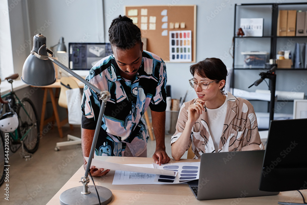 Portrait of two creative young people choosing color palette while ...