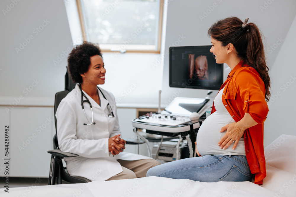Cheerful doctor with pregnant patient. Stock Photo | Adobe Stock