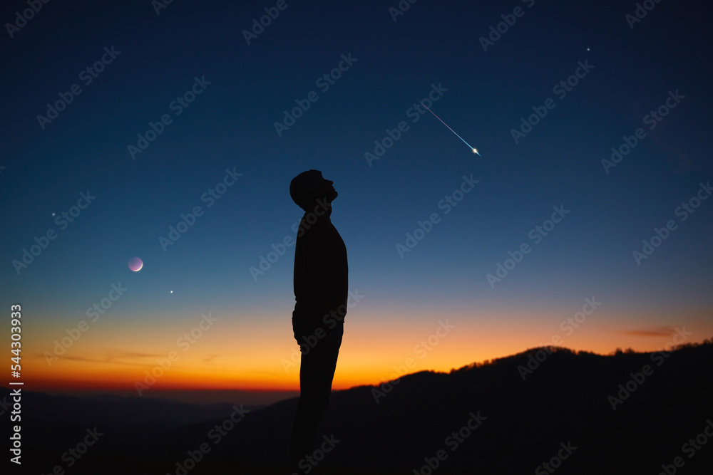 Man looking at the night sky, stars, planets, Moon and shooting stars ...