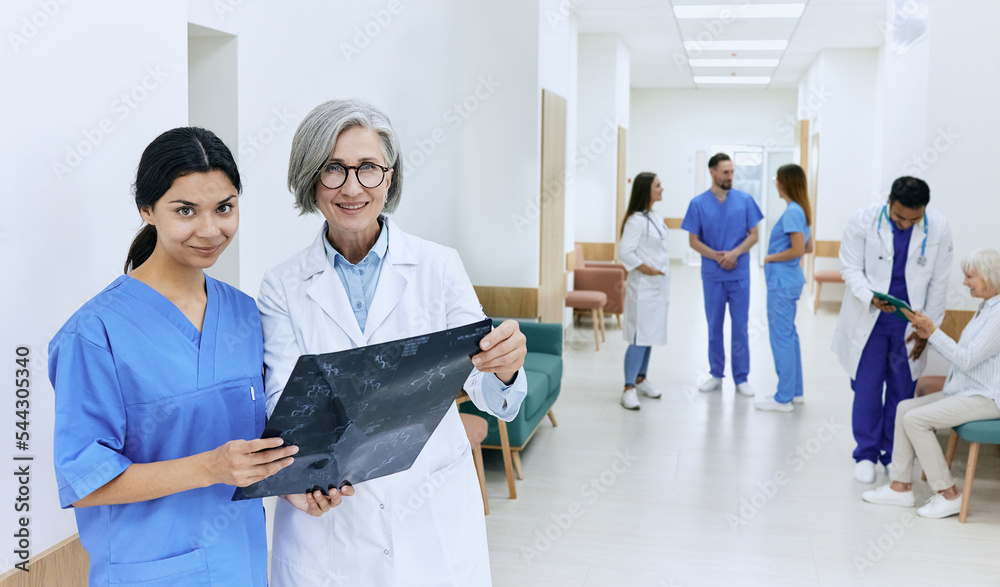 Foto de Female intern with her medical mentor in hospital corridor ...