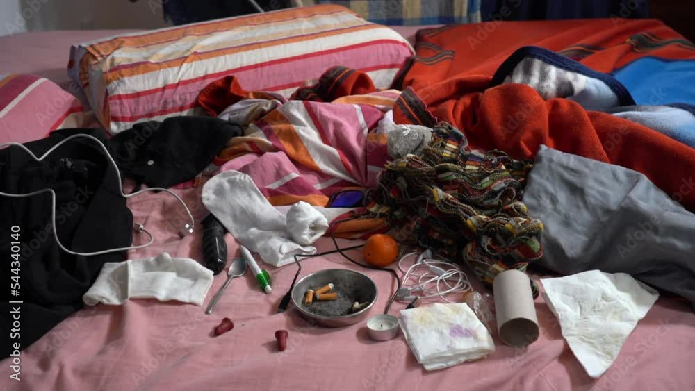 Dirty and messy bedroom. Unmade sleeping bed with various items ...