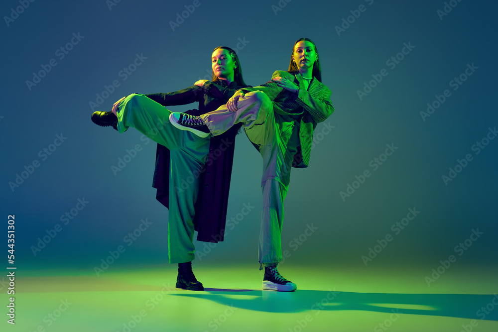 Synchronous. Stylish young girls in casual clothes dancing experimental ...