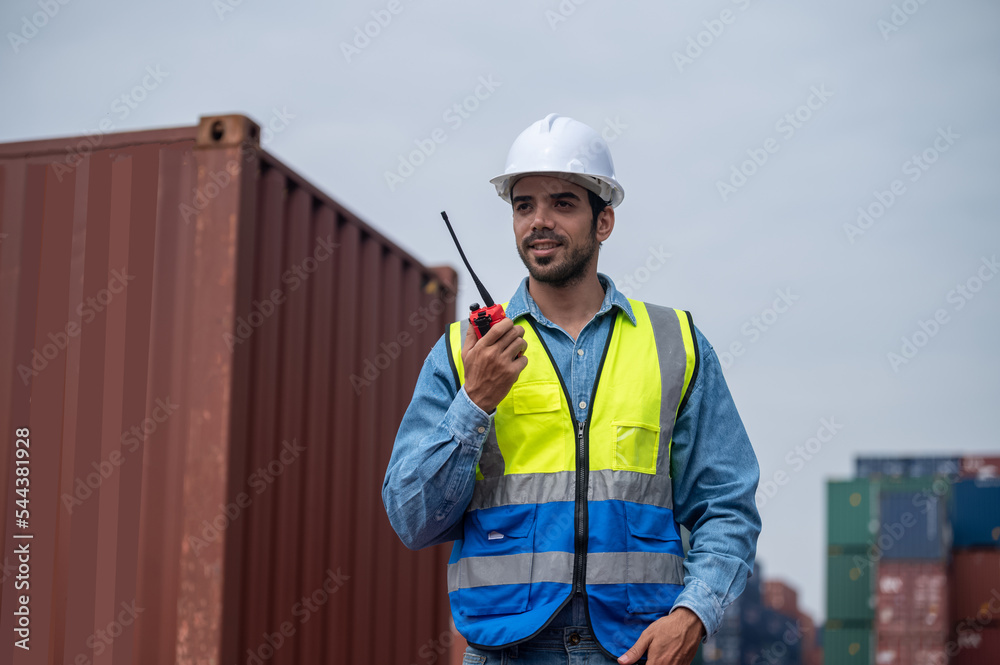 Logistic Manager talking on the walkie-talkie at container warehouse ...