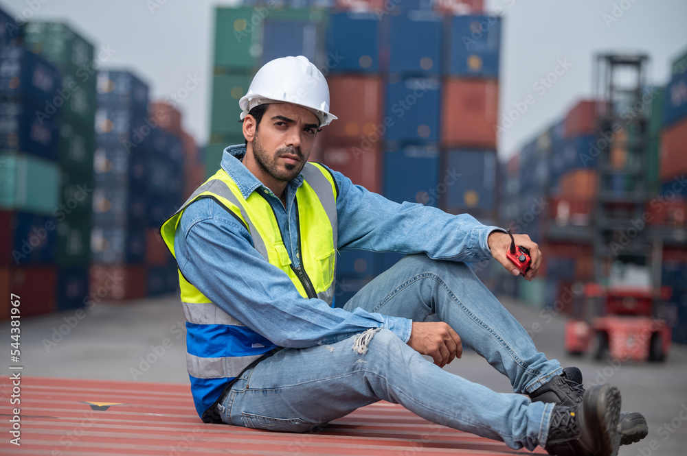 Logistic Manager talking on the walkie-talkie at container warehouse for control loading ...