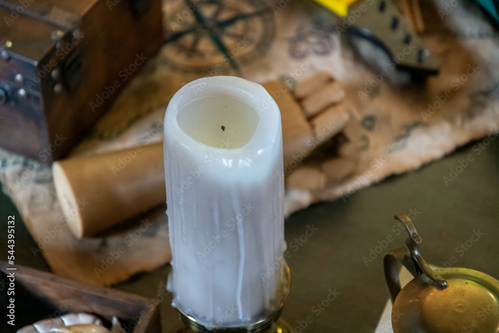 Pirate table with old candle and wooden hand with treasure map close-up ...