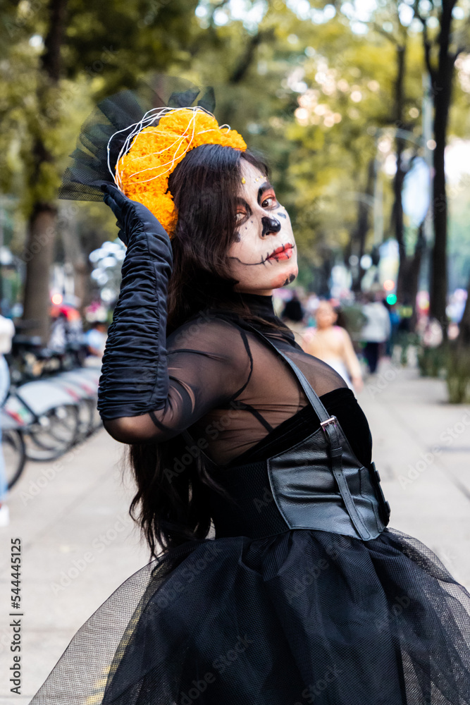 Mujer caracterizada como catrina con arreglo floral de cempasúchil en ...