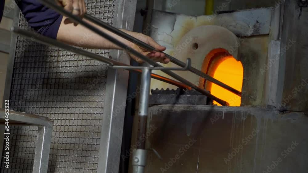 "Murano glass blowing factory. Workers put iron rod in furnace to make ...
