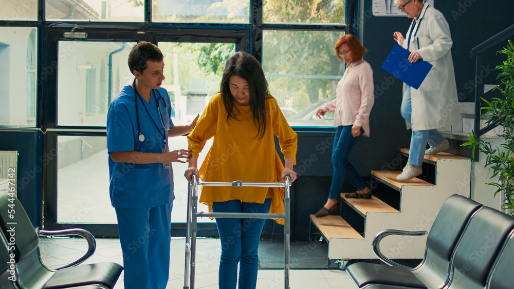 Asian patient using walking frame to walk in medical clinic, doing ...