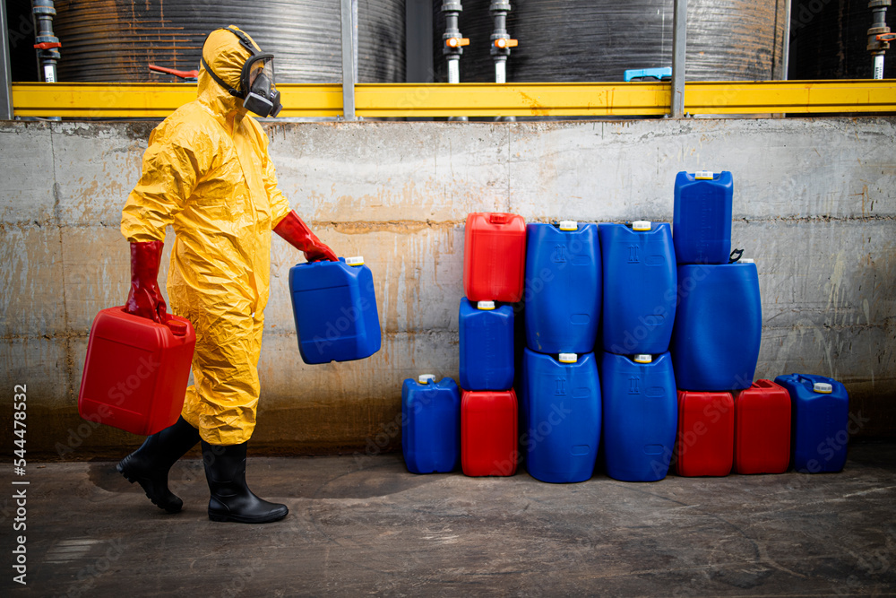 Chemical worker in hazmat protection suit and gas mask carrying ...
